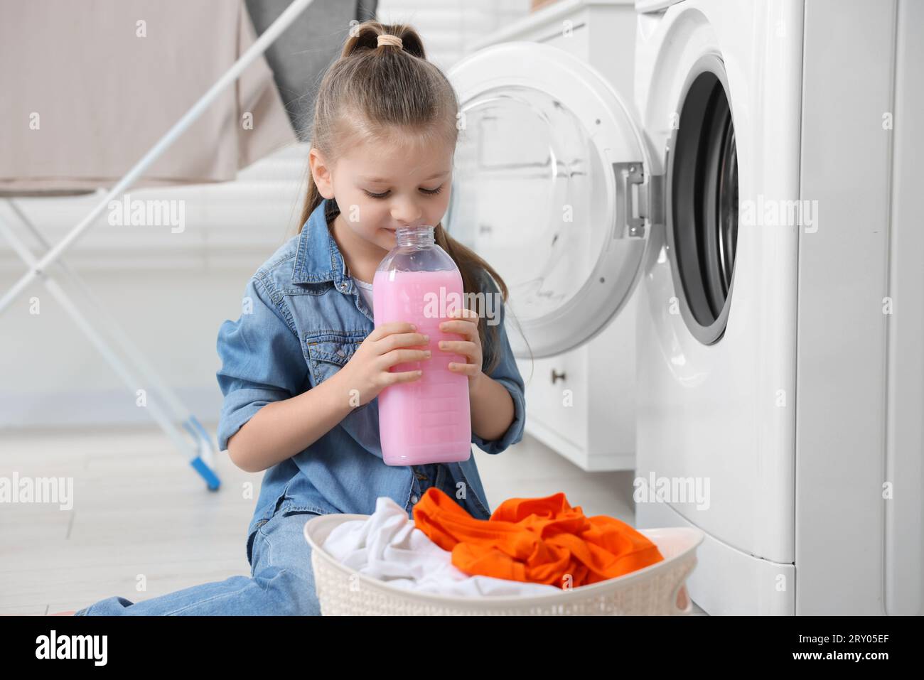 Little girl smelling fabric softener in bathroom Stock Photo - Alamy