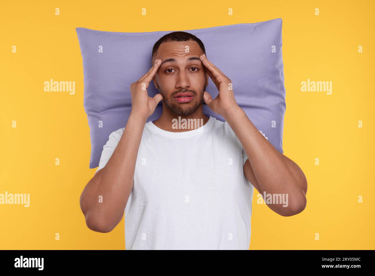 Tired man with pillow on orange background. Insomnia problem Stock ...