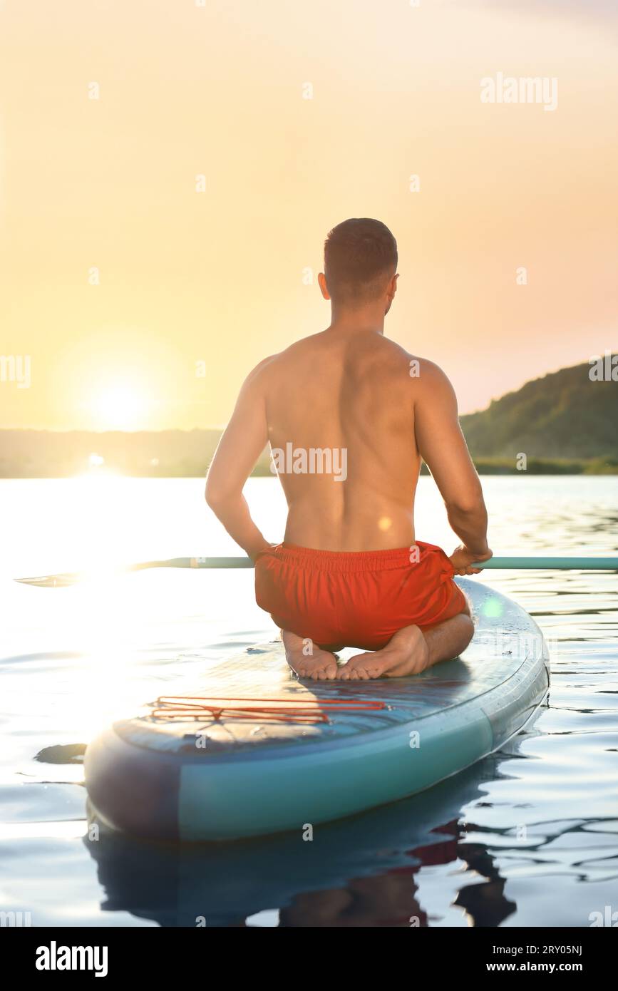 Man paddle boarding on SUP board in river at sunset, back view Stock ...