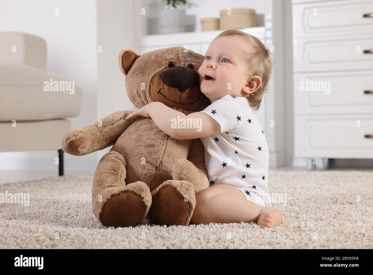 Cute little child with teddy bear on carpet at home Stock Photo - Alamy
