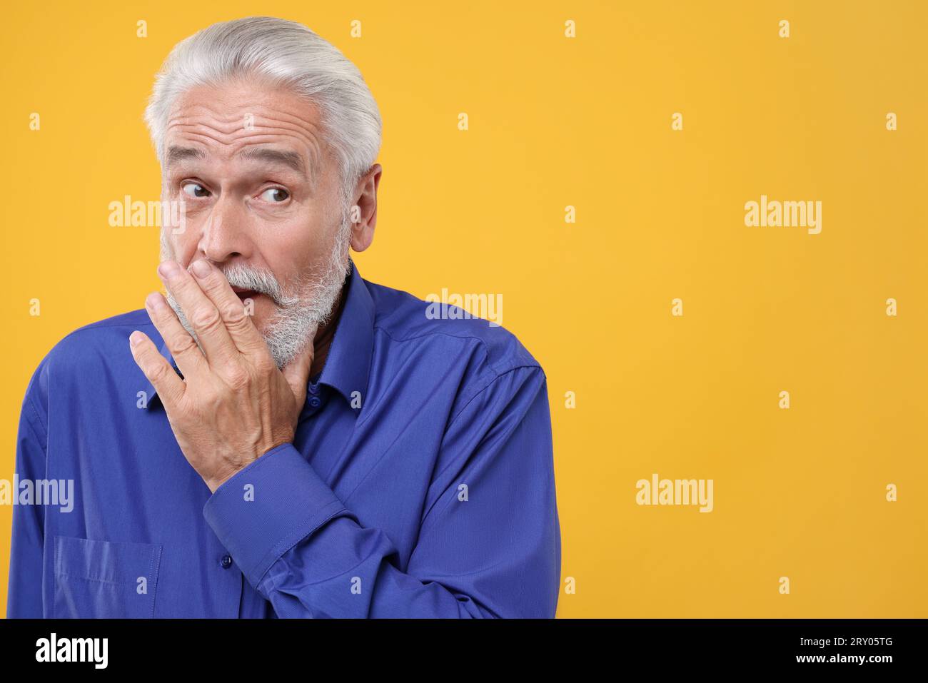 Embarrassed senior man on orange background. Space for text Stock Photo ...