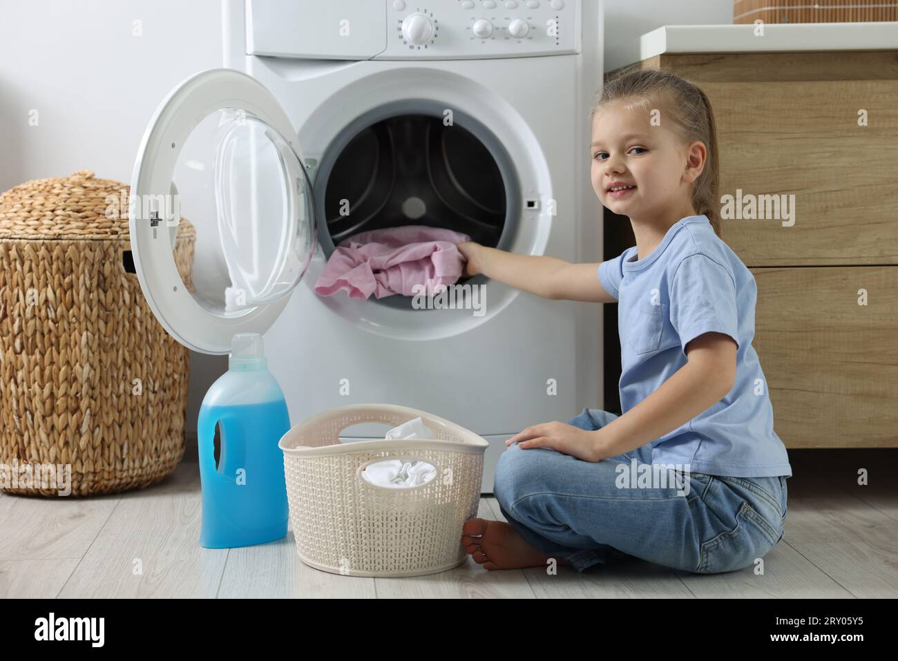 Child putting clothes washing machine hi-res stock photography and ...