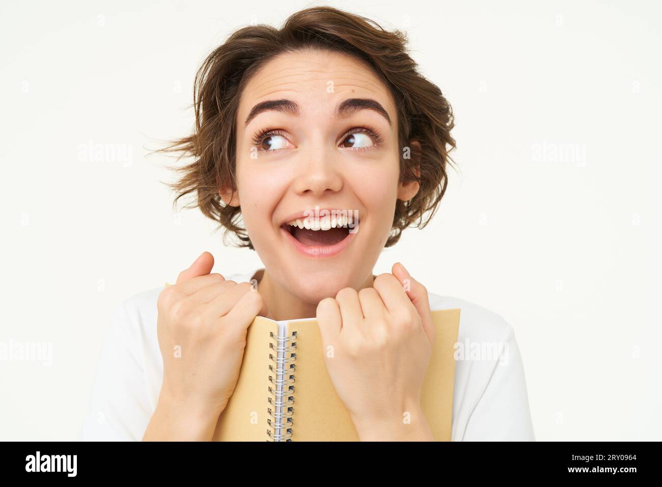Portrait of happy woman with planner, holding notebook, reading notes ...