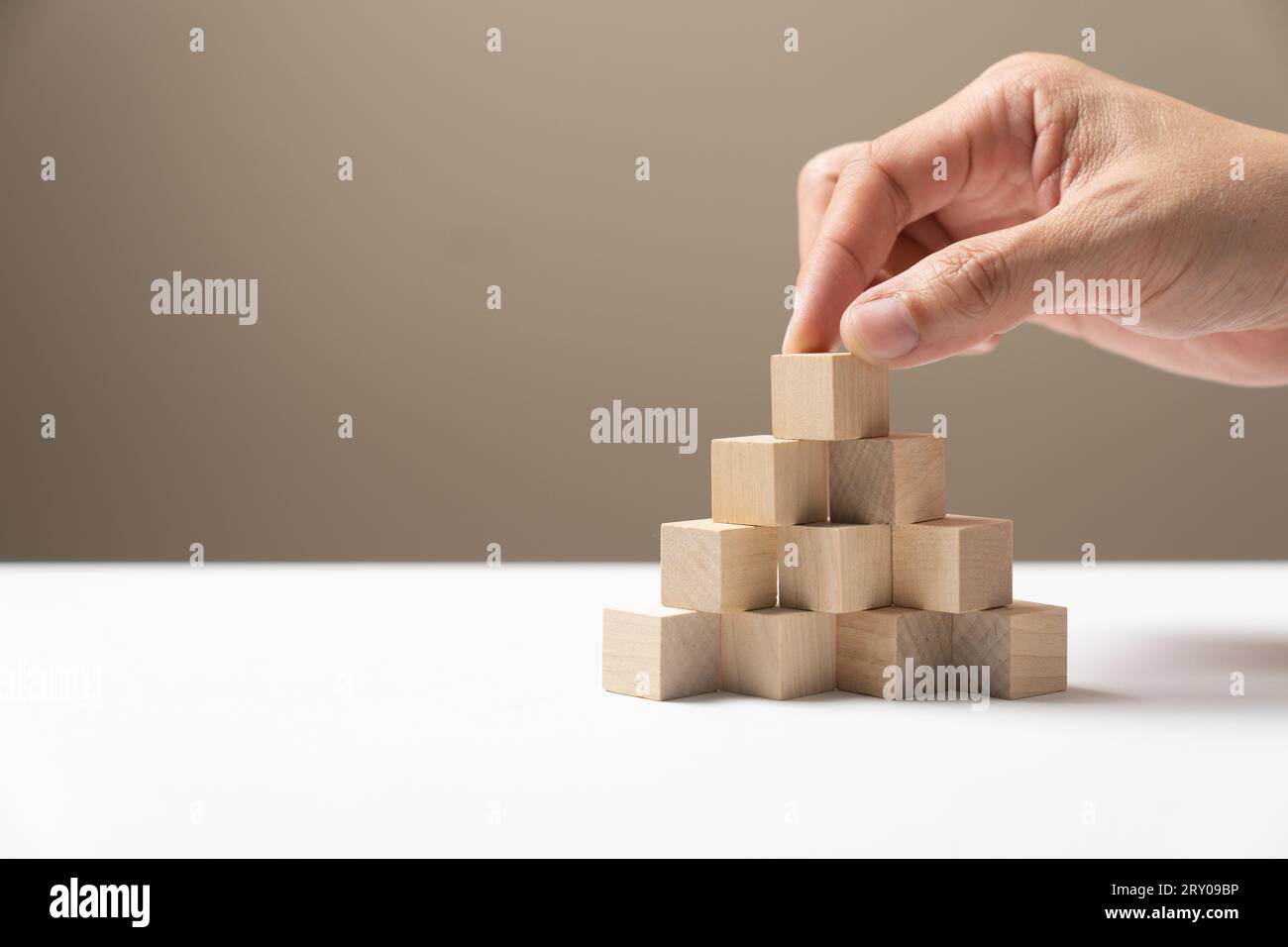 Hand putting wood cubes arrange in a pyramid shape mock-up Stock Photo ...