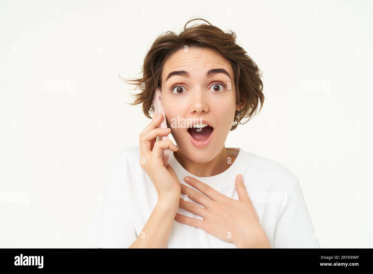 Portrait of woman with surprised face, answers phone call and looks ...