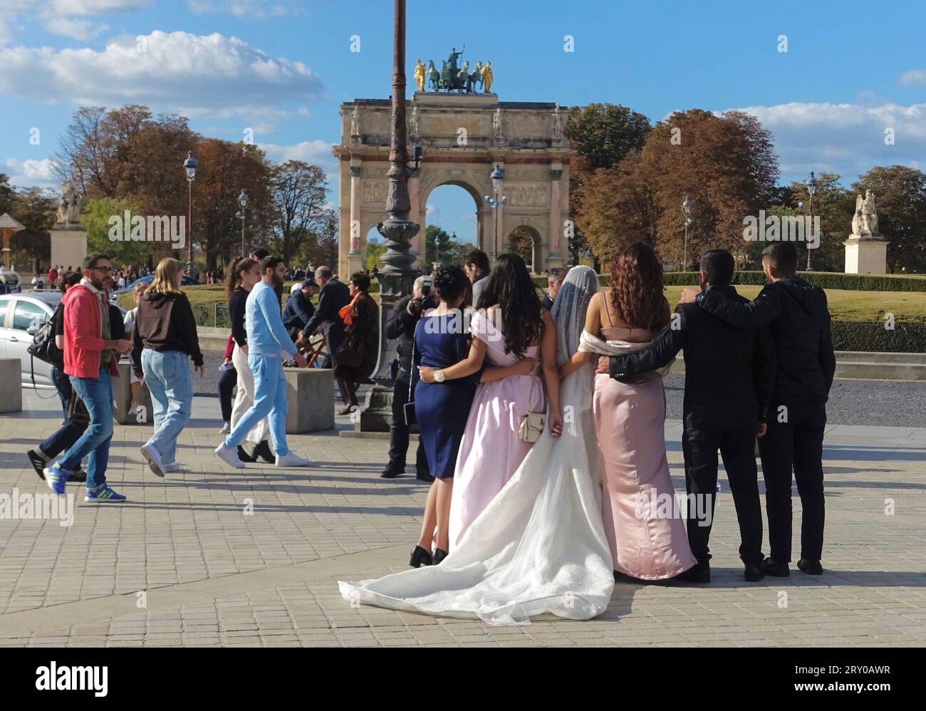 Immigrant wedding group poses for a photograph in front of the Arc de ...