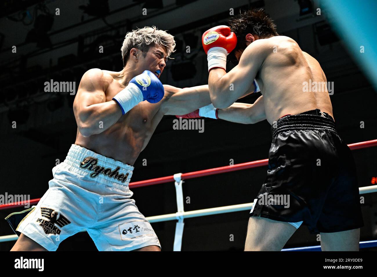 Ryohei Ibuki (blue gloves) hits Eigoro Akai (red gloves) in the first ...