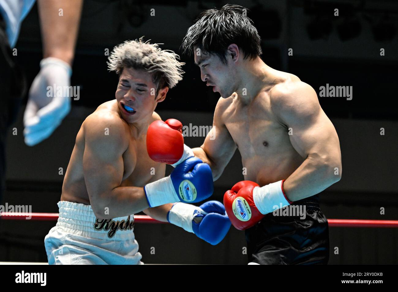 Eigoro Akai (red gloves) hits Ryohei Ibuki (blue gloves) in the first round during the 2023 East ...