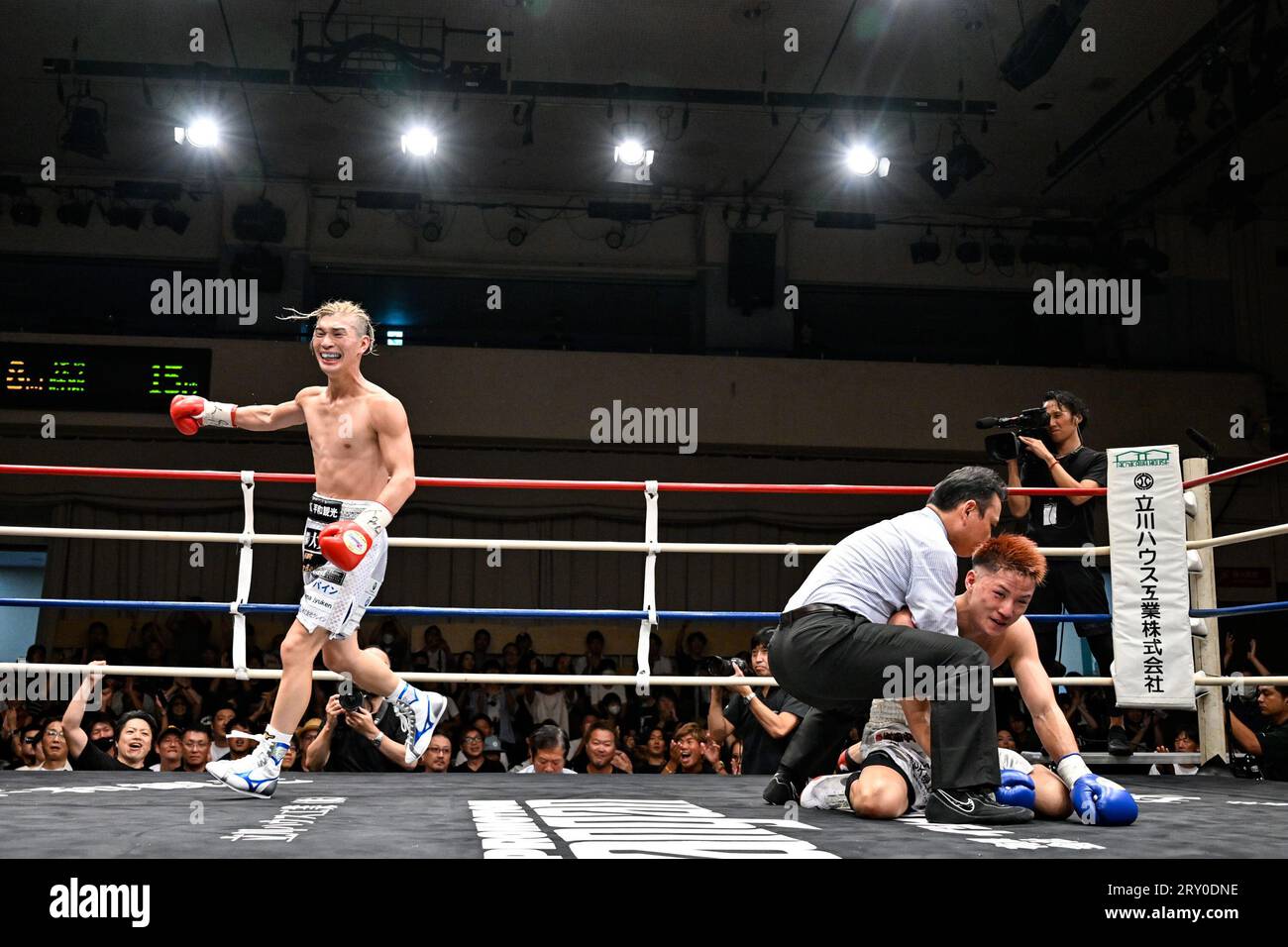 Suzumi Takayama (red gloves) celebrates his eighth round TKO victory ...