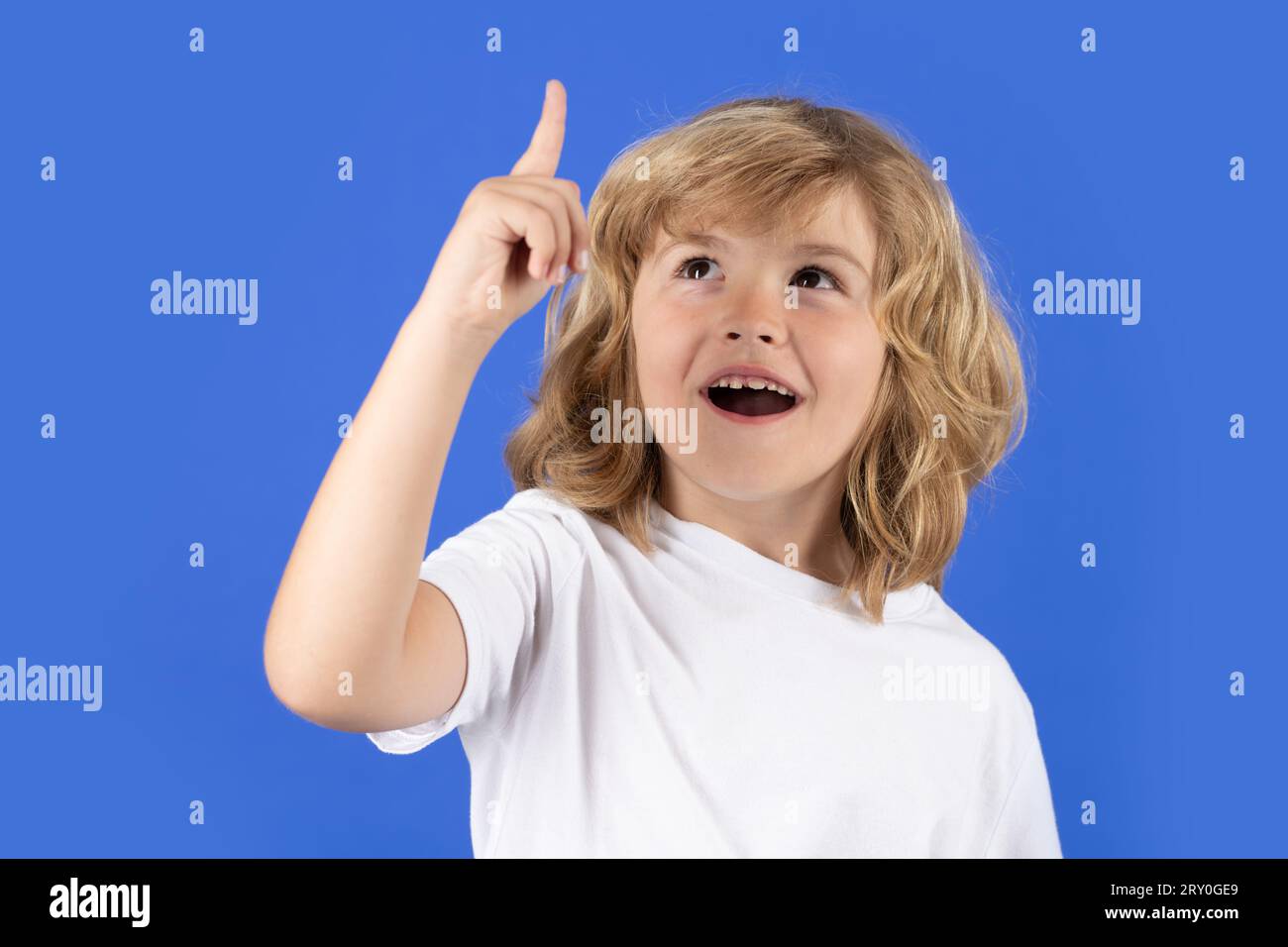 Excited kid boy have idea on blue isolated background. Surprised face ...