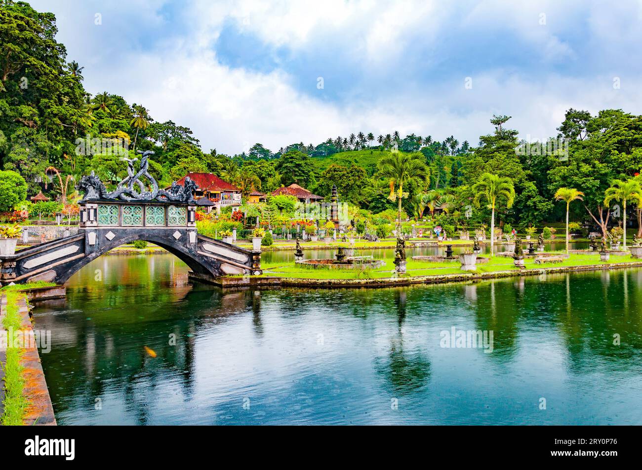 Stone bridge over a pond in a water palace Tirta Gangga in the rainy ...