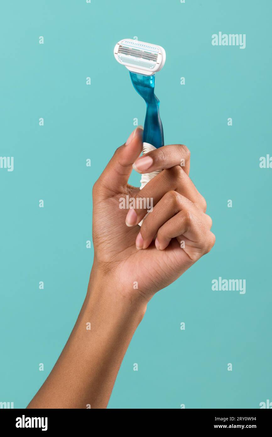 Hand of unrecognizable African American female with razor against ...