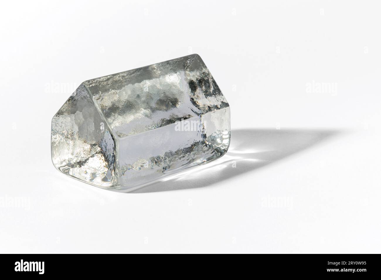 Translucent house made of whole piece of fragile glass casting shadow ...