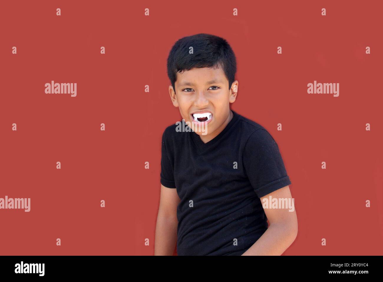 9-year-old dark-skinned Latino boy wearing vampire costume teeth to ...