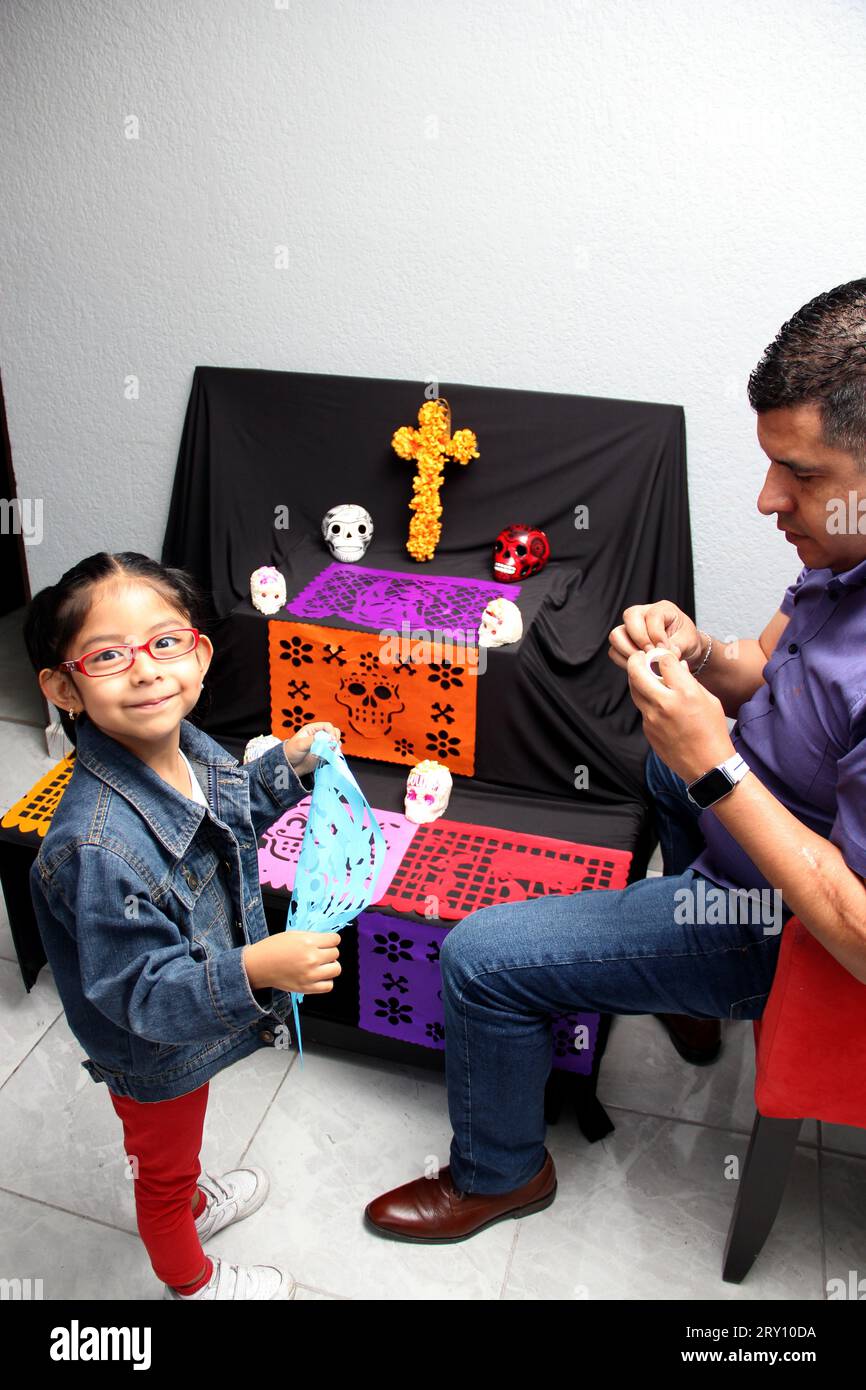 Mexican dad and daughter put the altar and offering of the Day of the ...