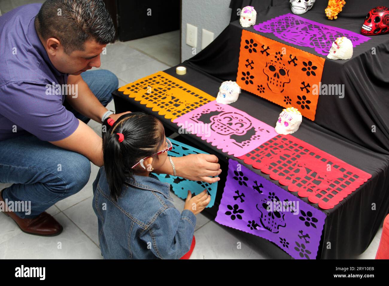 Mexican dad and daughter put the altar and offering of the Day of the ...
