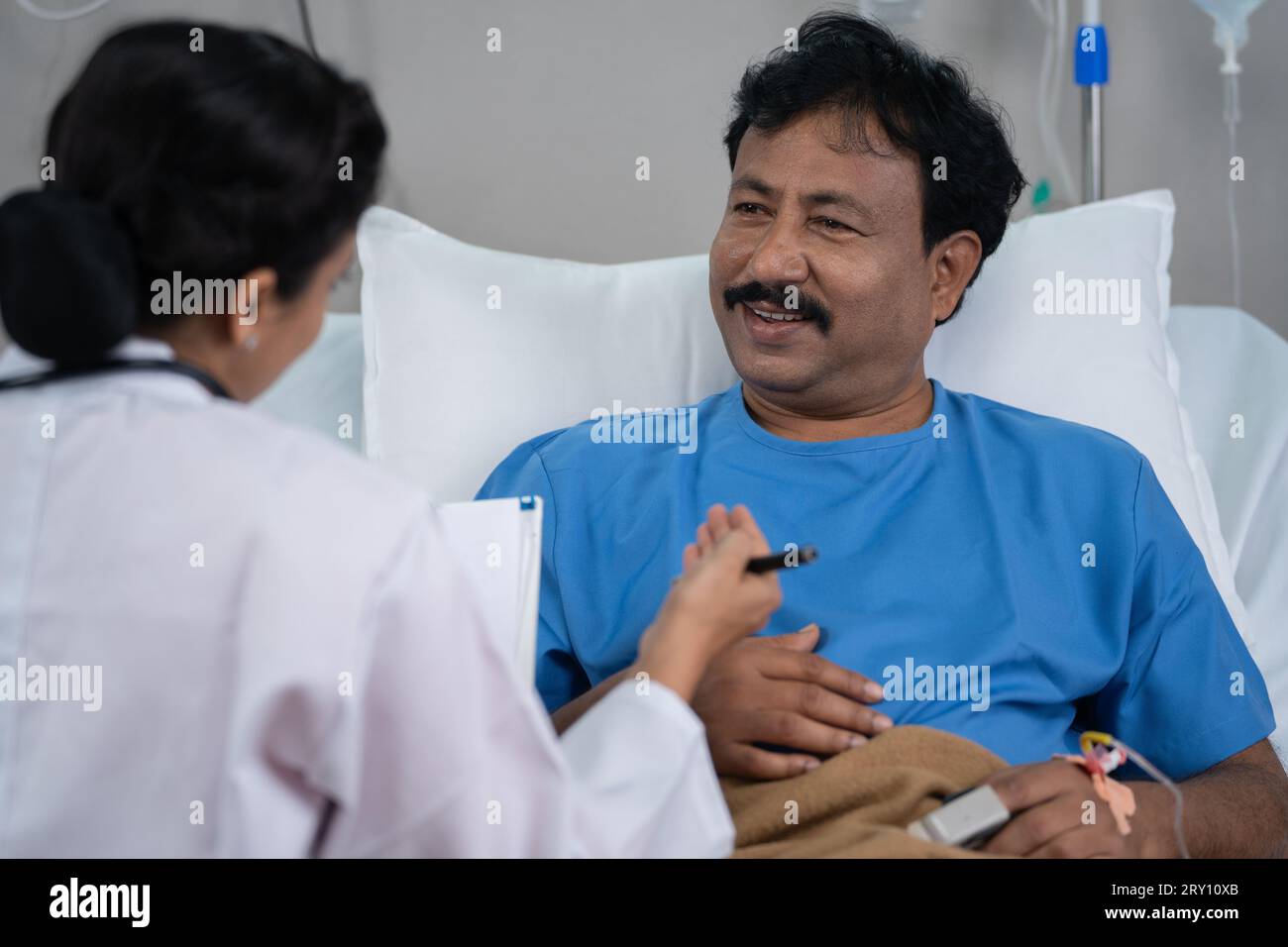 Shoulder shot of indian doctor consoling sick admitted recovered ...