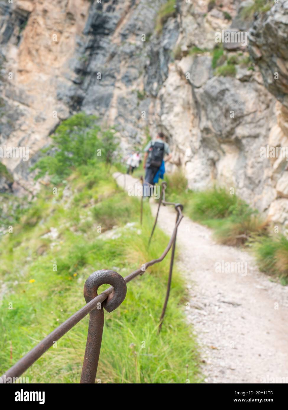 Rope and shackles anchored in hard dolomite limestone rock. Climbers ...