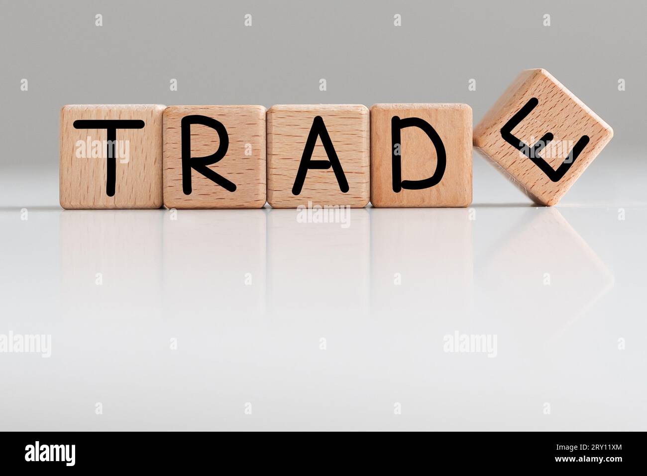 Word TRADE is made of wooden building blocks lying on the table and on ...