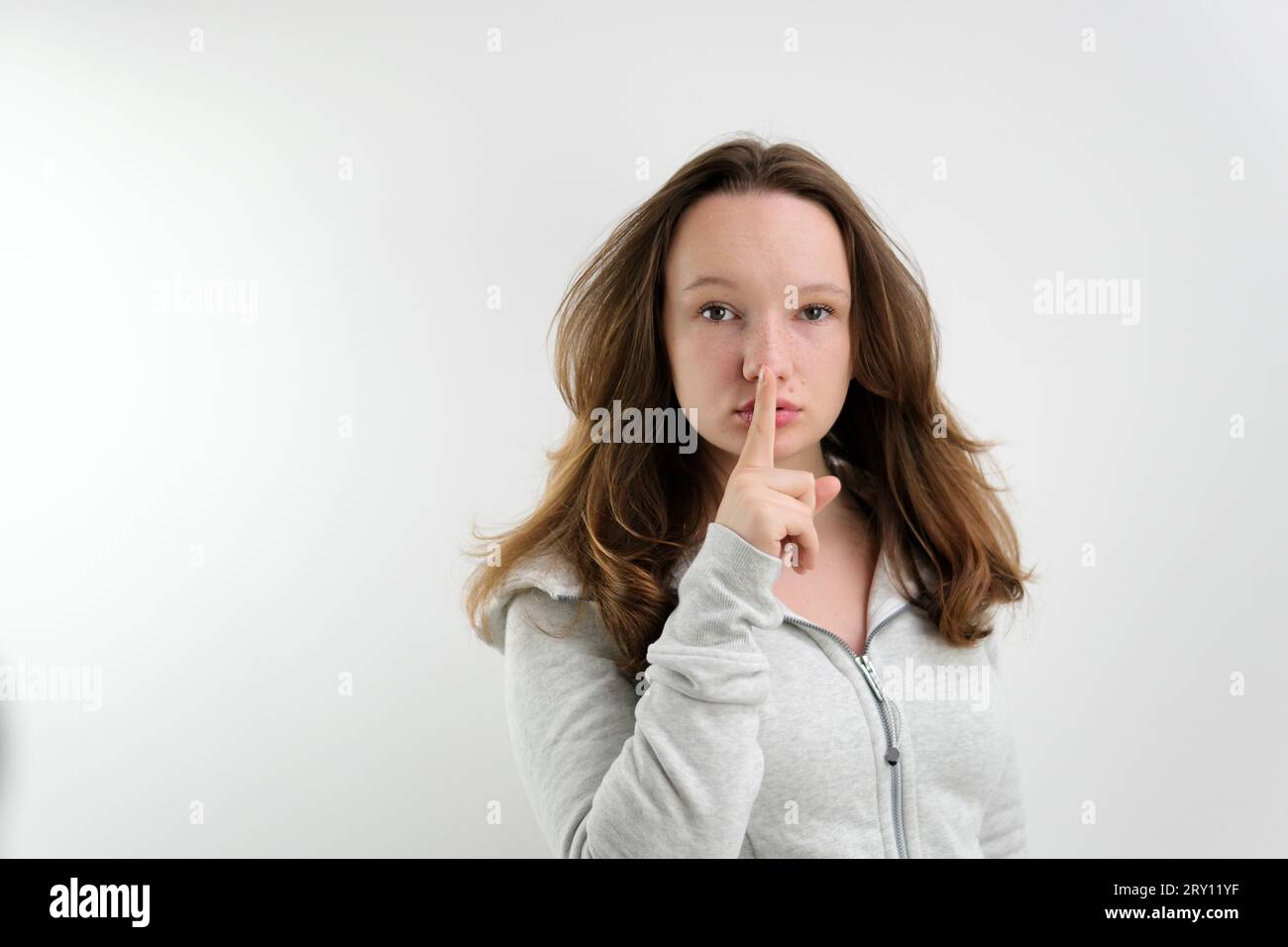 Young woman says ssshhh to maintain silence on a white background. High ...