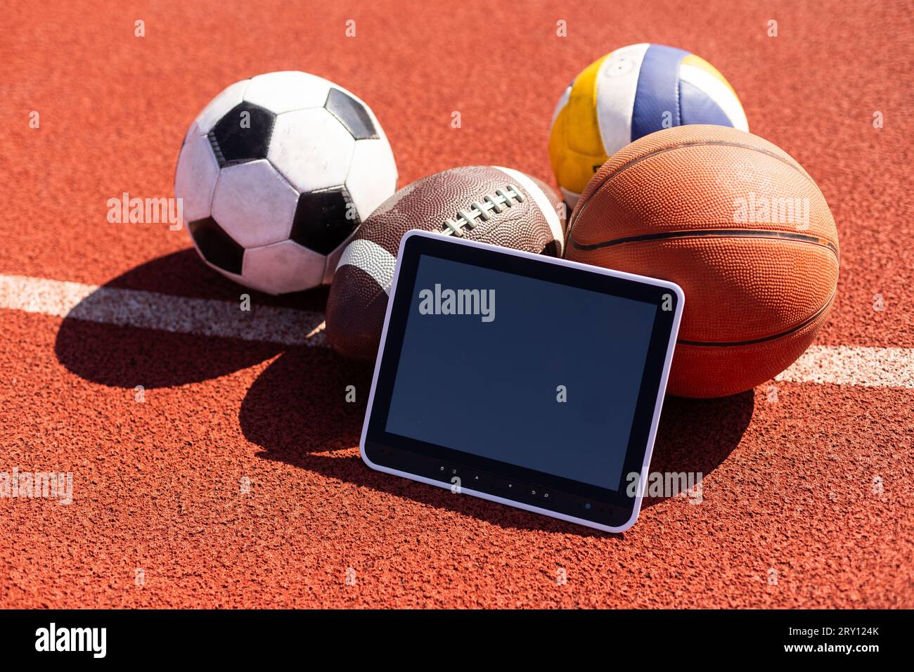 balls and tablet computer on color background. Concept of sports bet ...