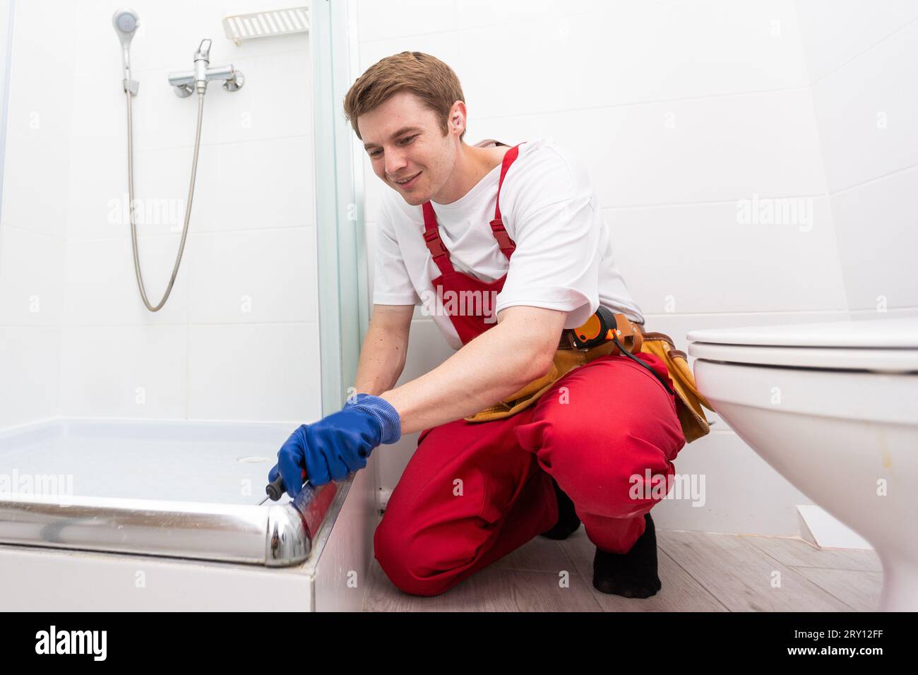 Plumber installing a shower cabin in bathroom Stock Photo - Alamy