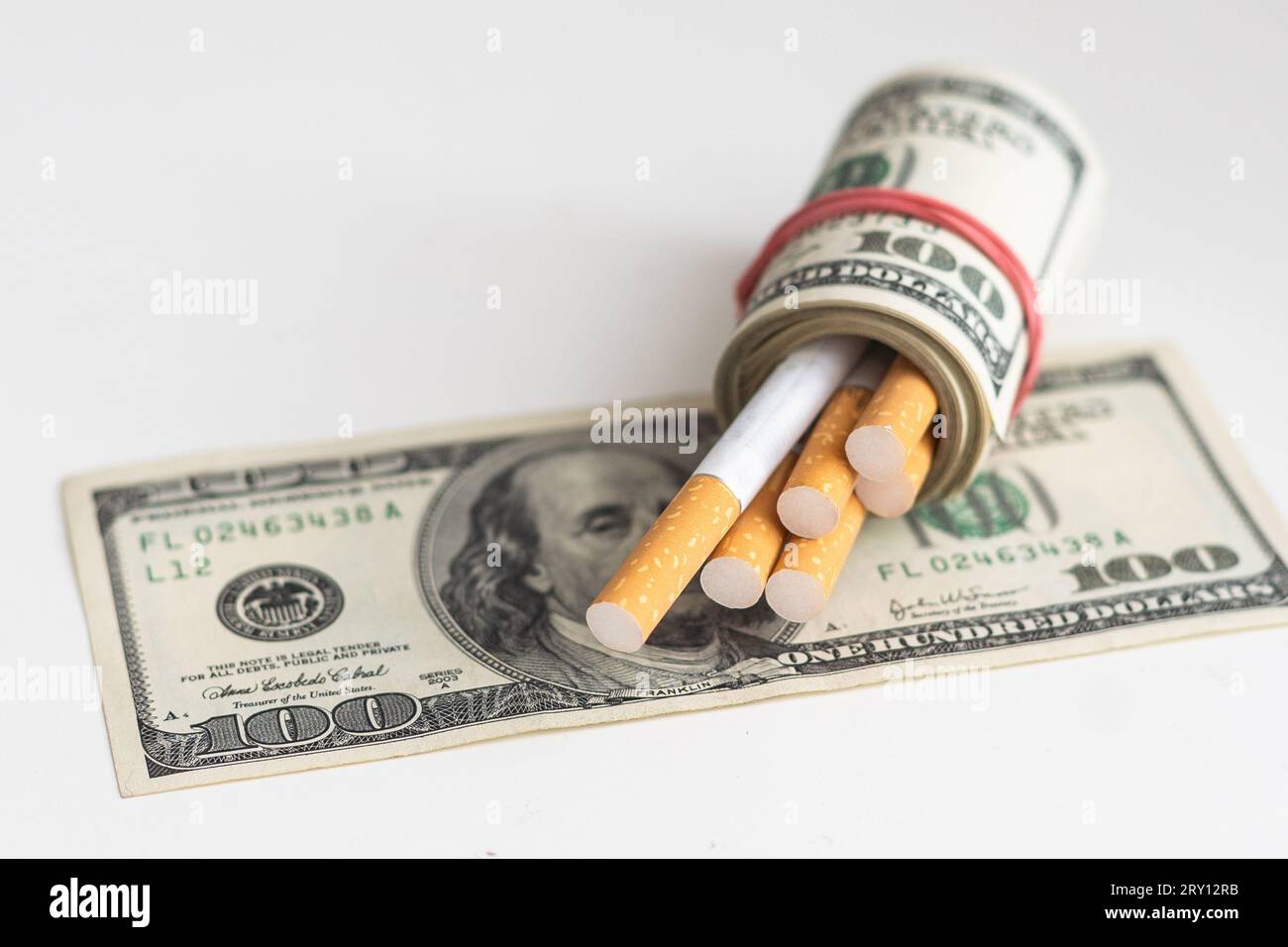 cigarettes and money. expensive habit. white background - horizontal ...