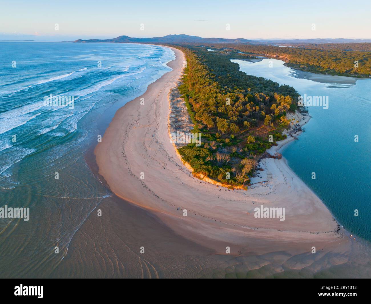 Aerial view of a coastal river flowing out to sea past islands and sand ...