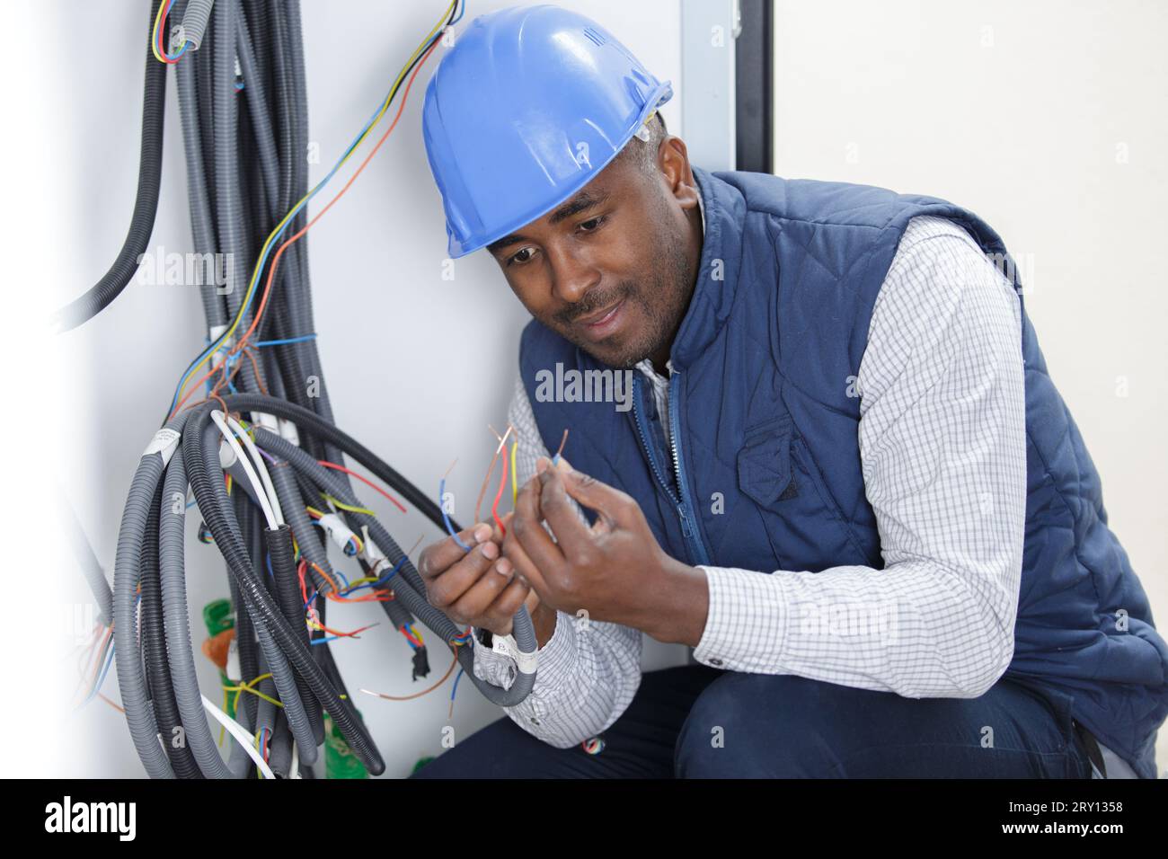electrician checking the voltage level in wall socket cables Stock ...