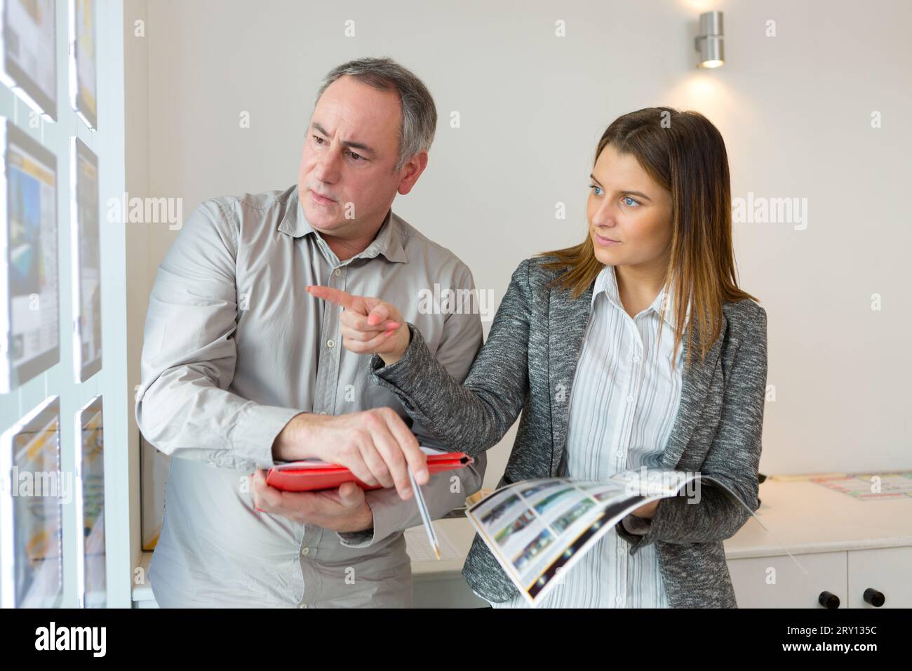 teamwork standing in an office near looking at catalog Stock Photo - Alamy