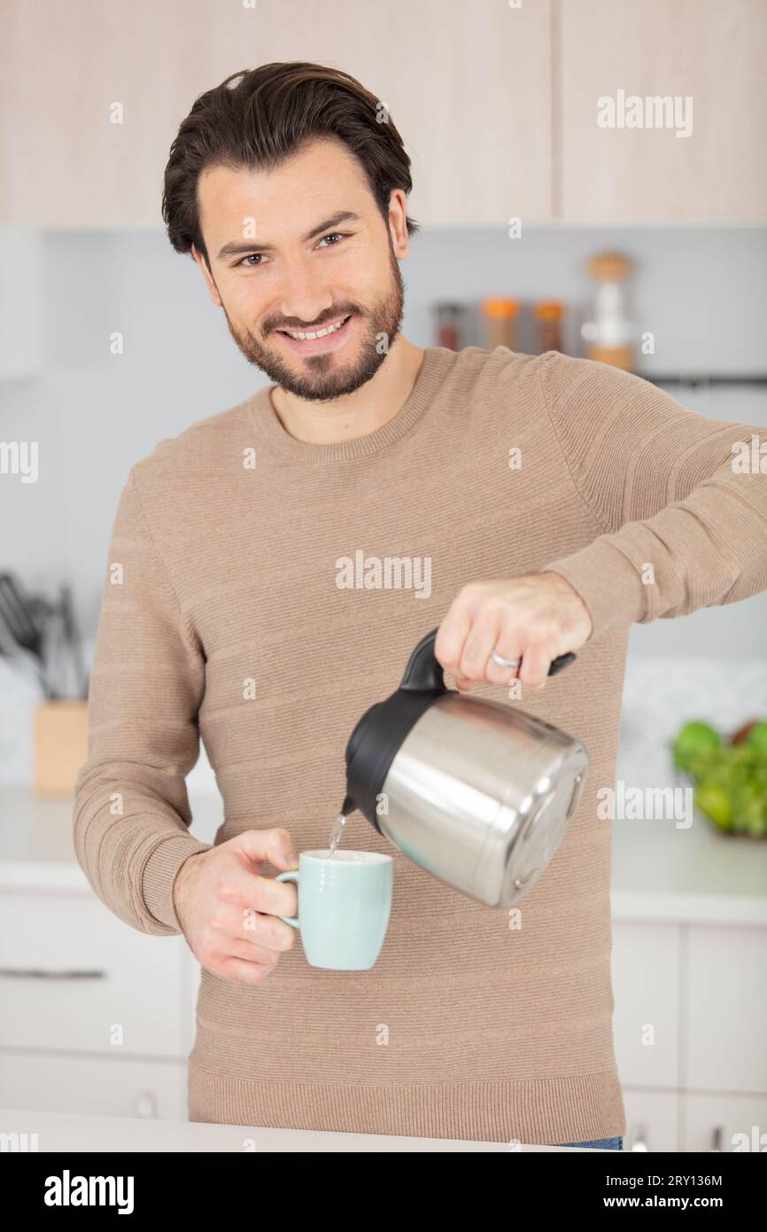 young elegant man pouring tea in cup Stock Photo - Alamy