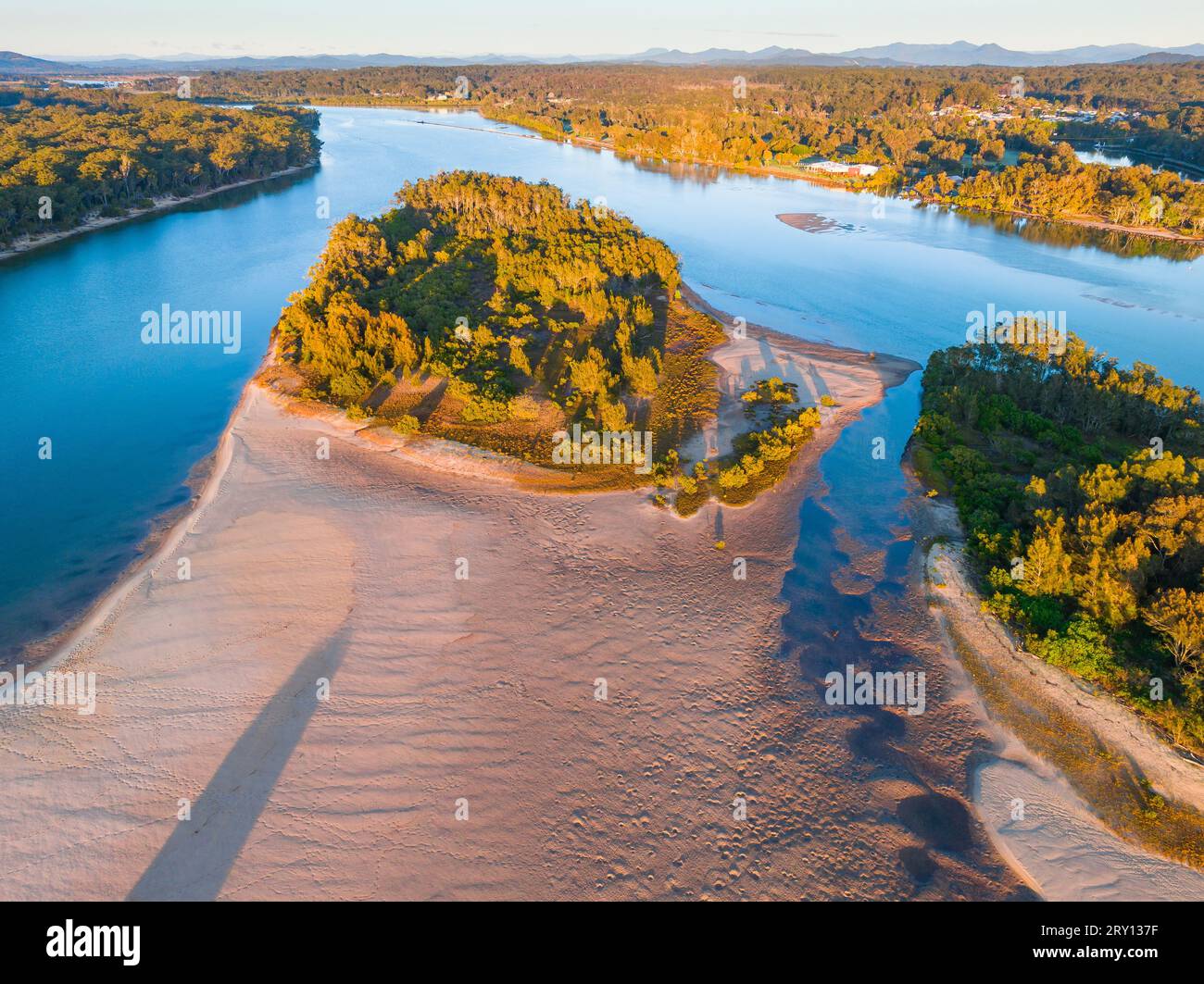 Aerial view of a coastal river flowing out to sea past islands and sand ...