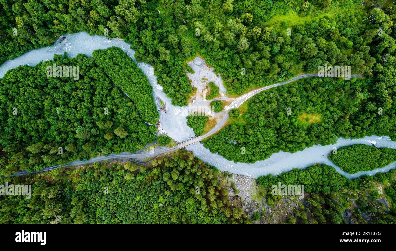 Stunning symmetrical view of the forest S-form river with off-road path ...