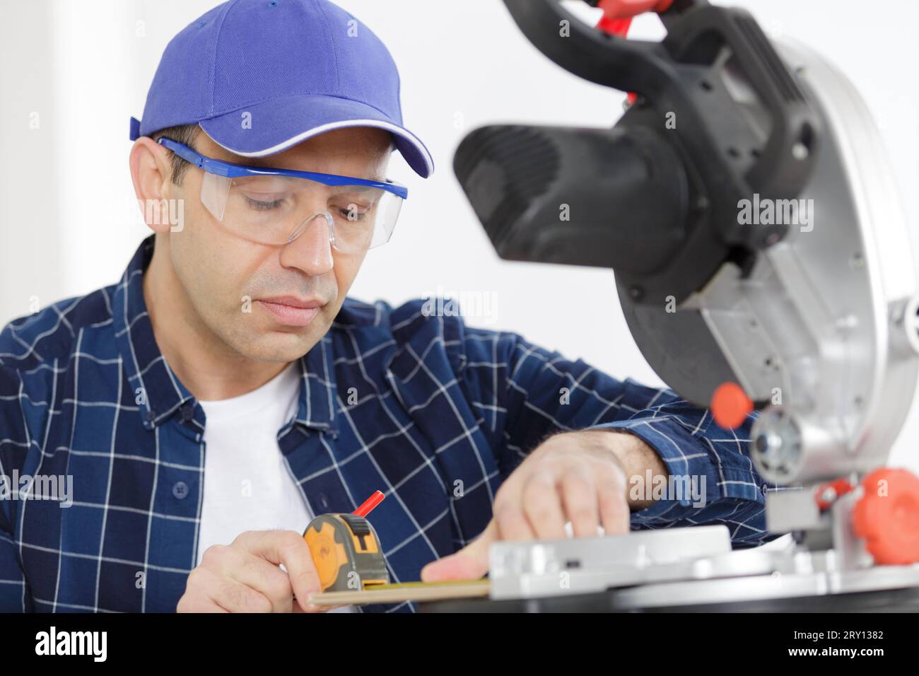 skilled carpenter cutting a piece of wood in his workshop Stock Photo ...