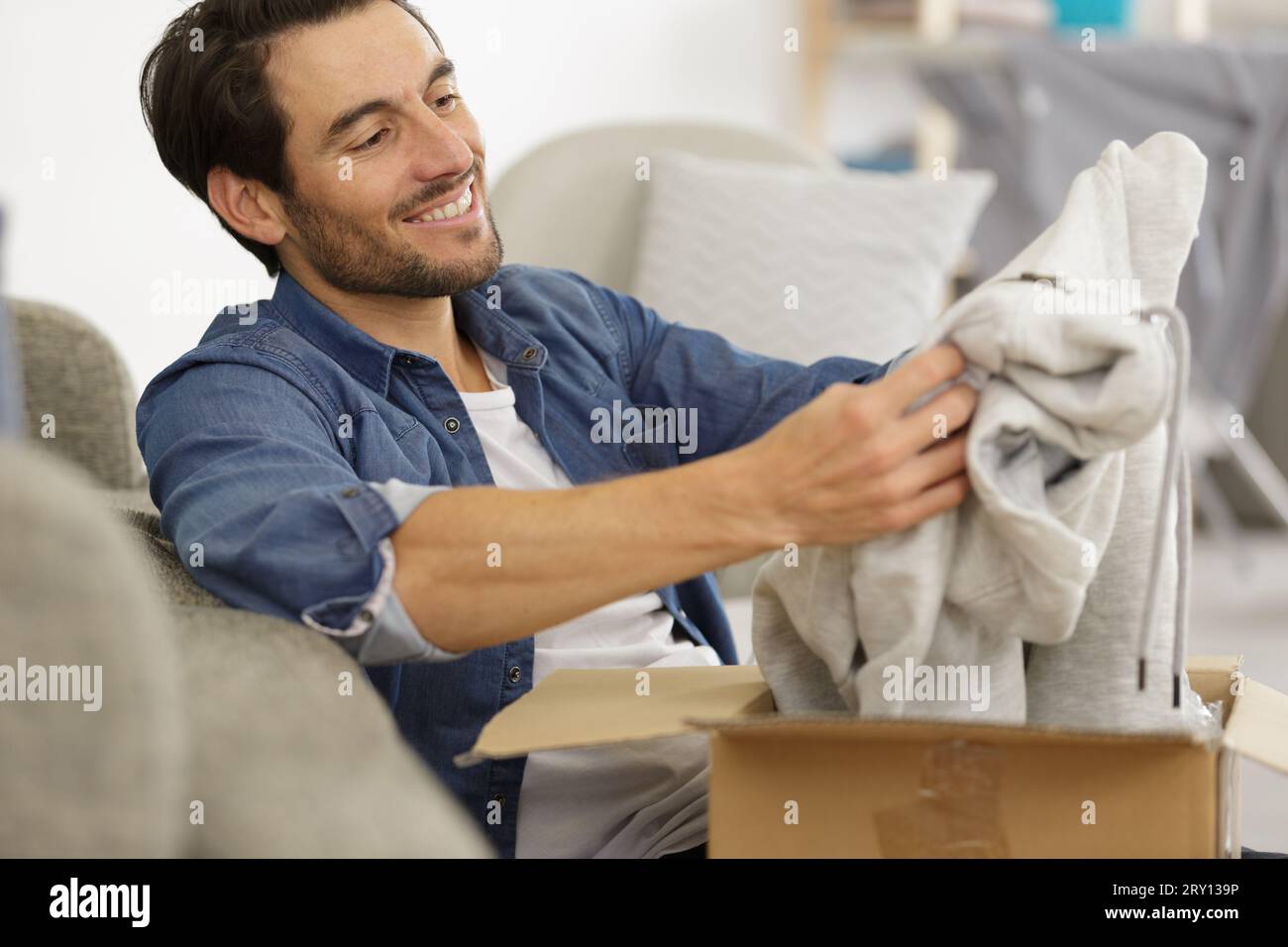 happy man opening a parcel Stock Photo - Alamy