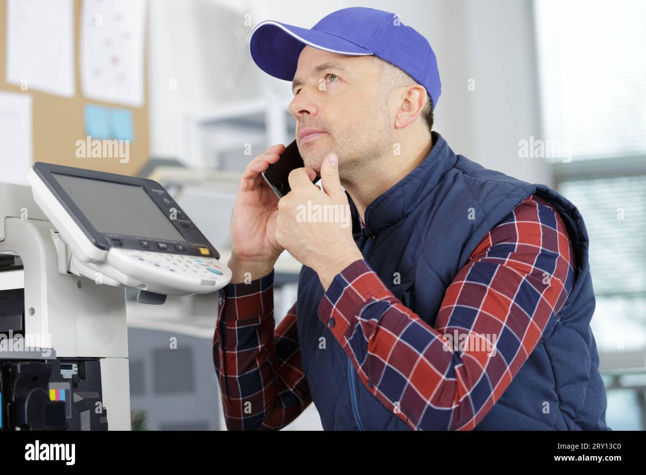 man technician working on broken printer calling the customer Stock ...