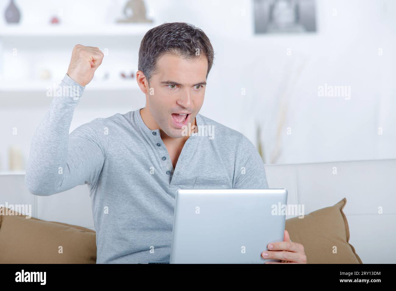 Man looking at computer making sign of victory Stock Photo - Alamy