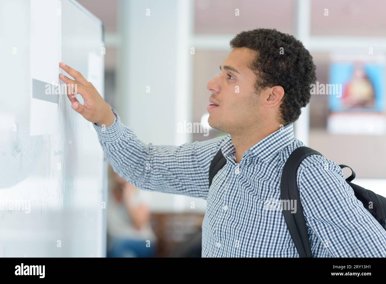 young male student checking notice board Stock Photo - Alamy