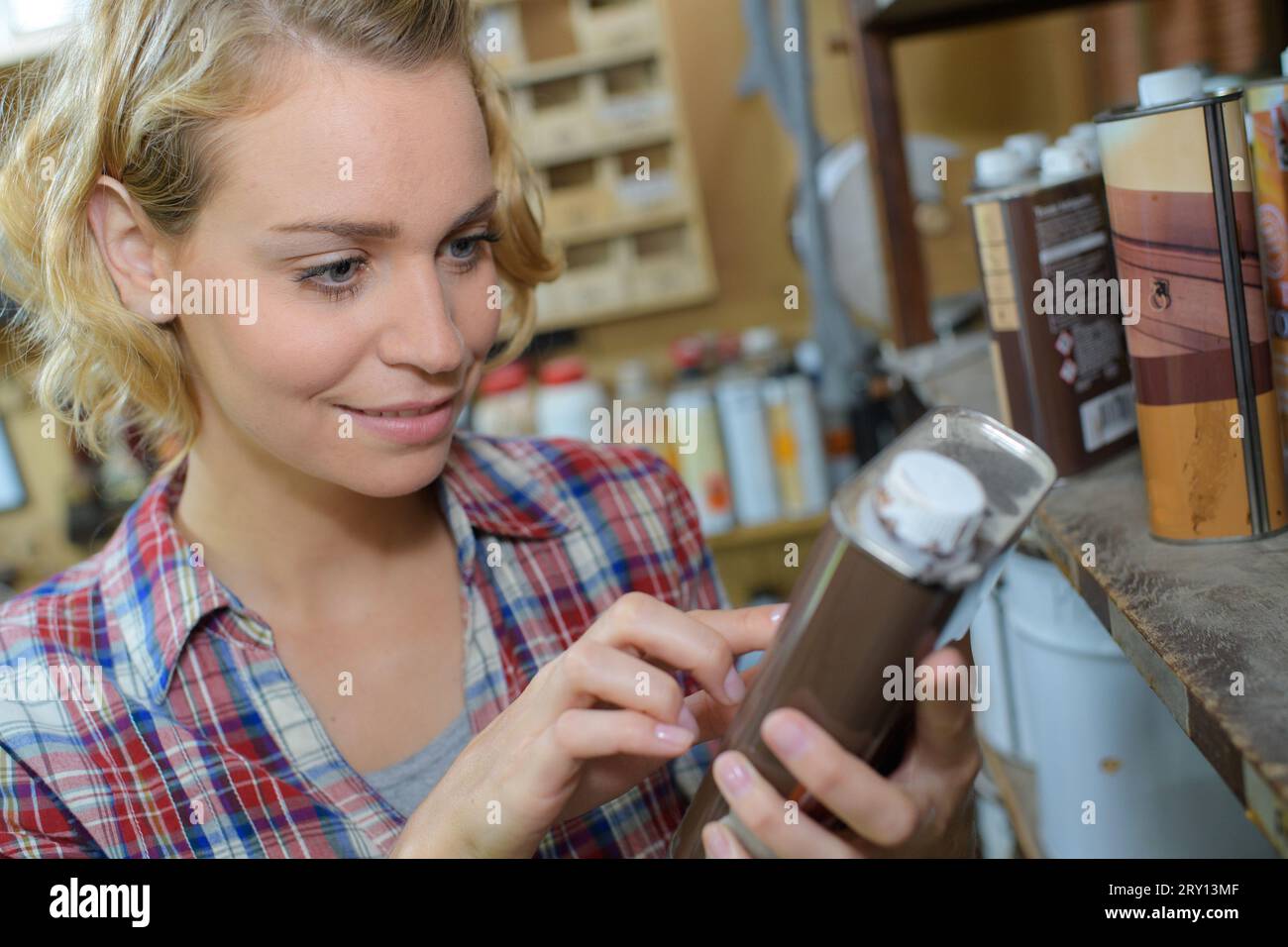 glad woman customer looking for paint solvent in bottle Stock Photo - Alamy