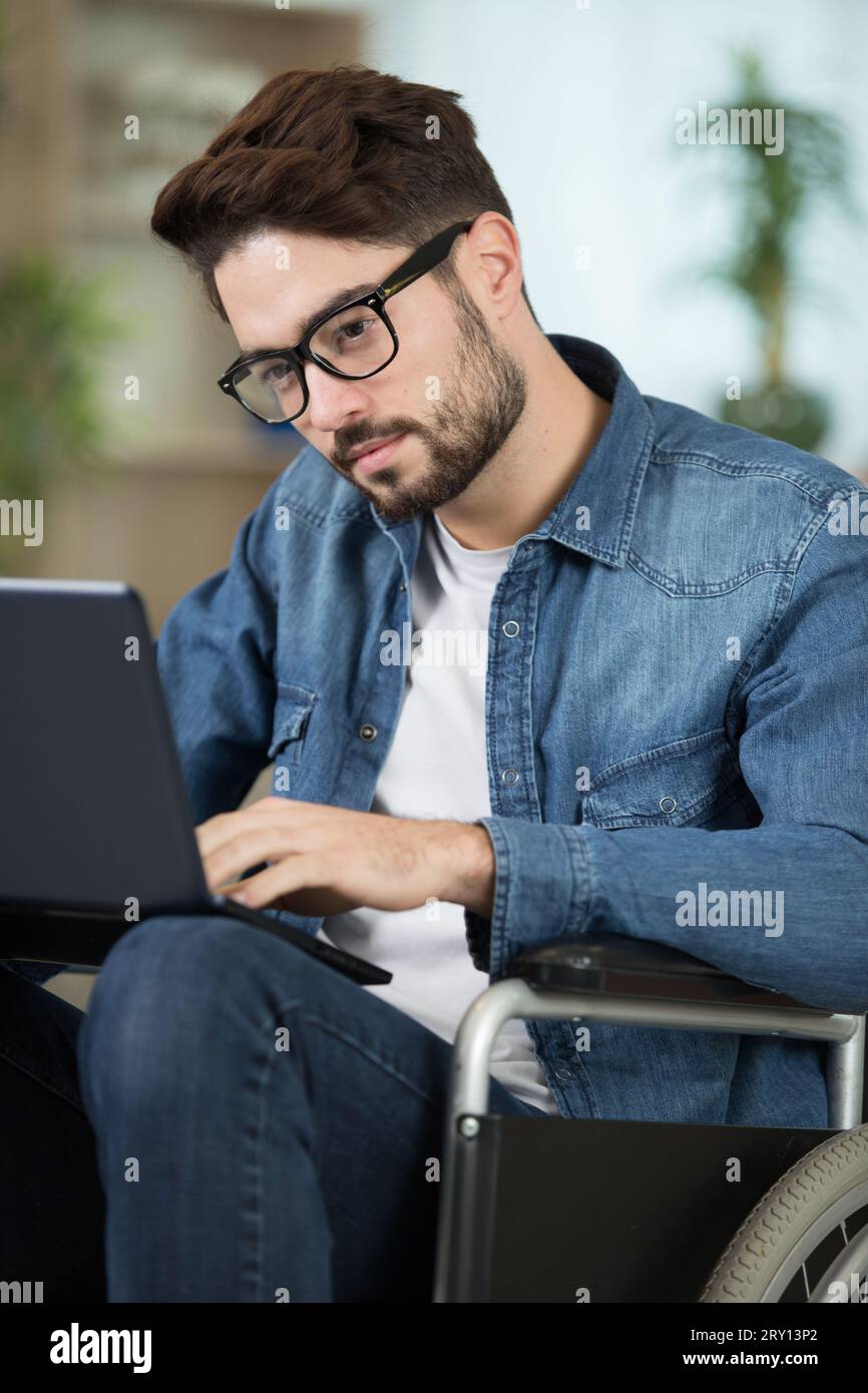 young disable man using laptop and working from home Stock Photo - Alamy