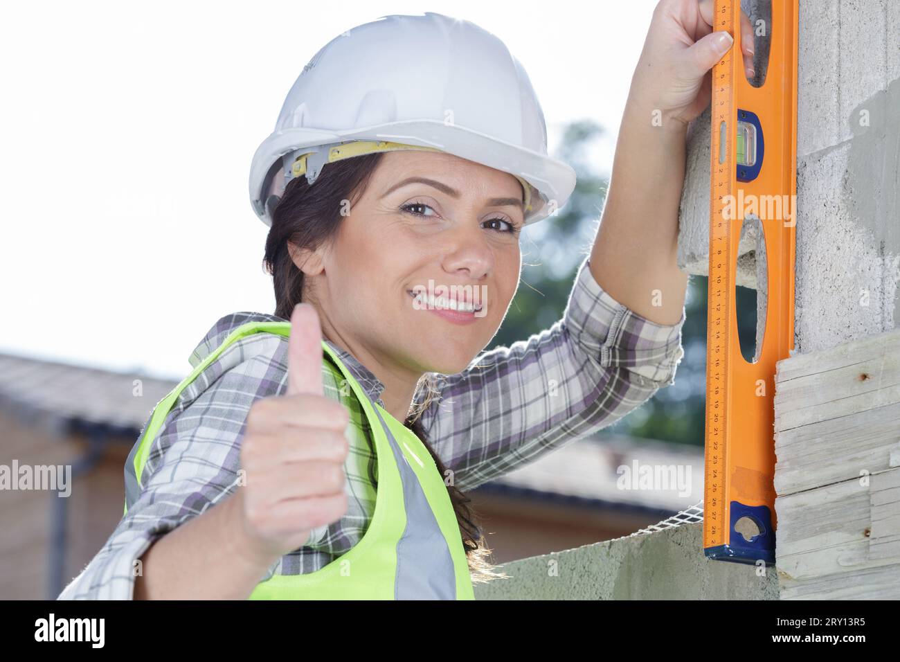 young smiling woman using spirit level Stock Photo - Alamy