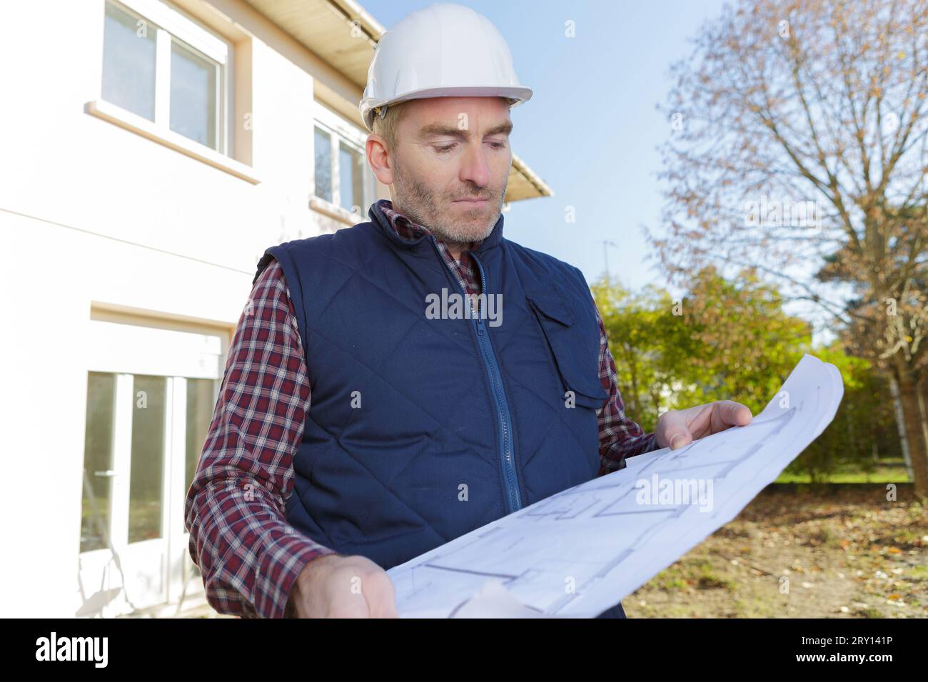 industrial engineer at work looking at technical drawing plans Stock ...