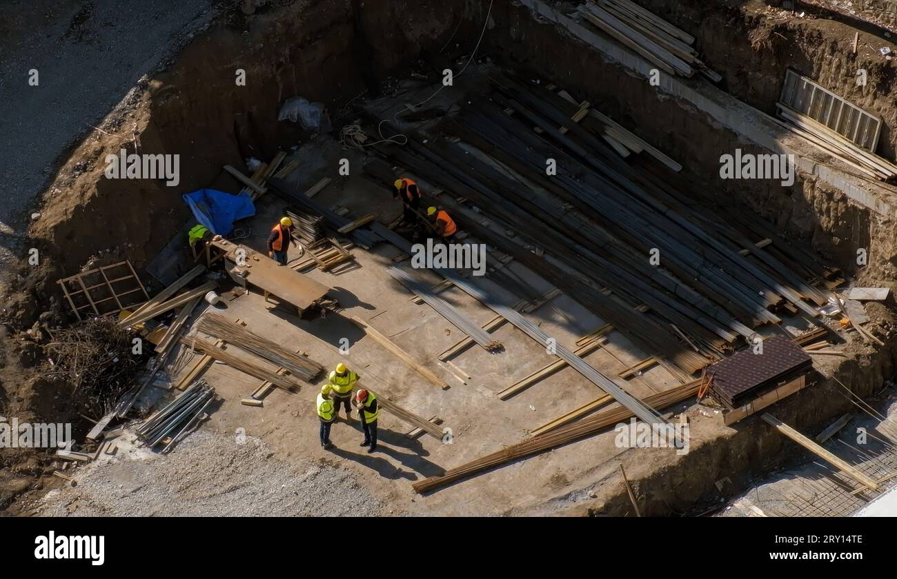Workers in orange and yellow uniform working and talking at the ...
