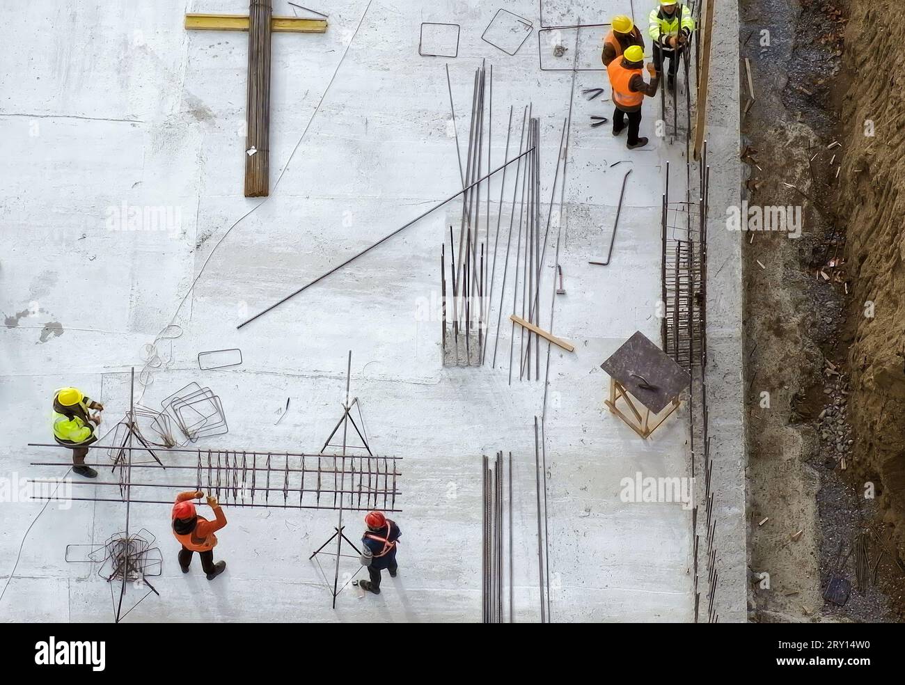 Workers in orange and yellow uniform working with reinforcement at the ...