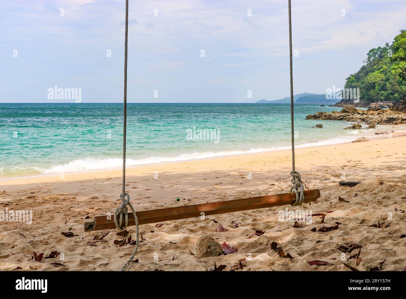 Homemade swing against the backdrop of a beautiful sea with azure water ...