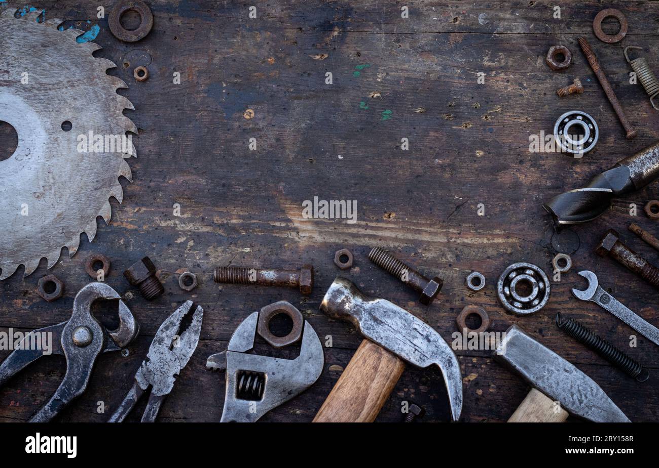 Old work tools nuts, bolts and bearings lie on a wooden workbench Stock ...