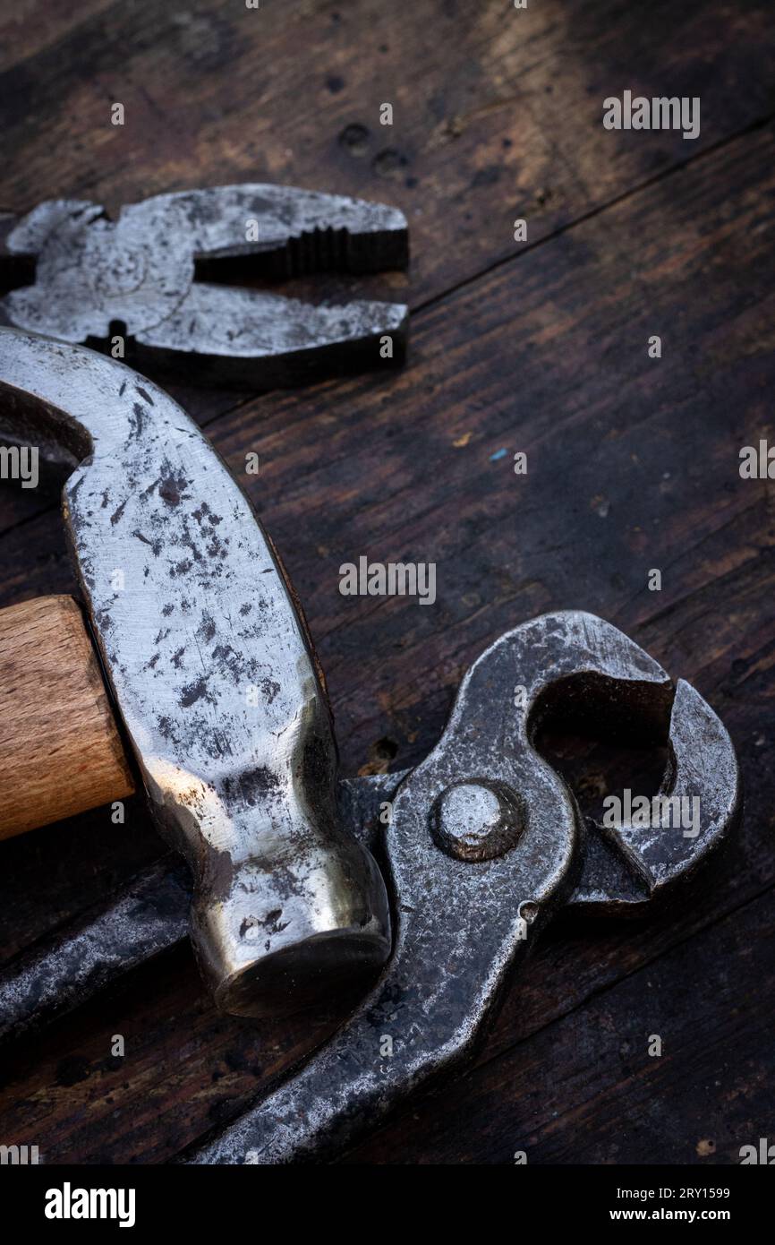 Old pliers, hammer and pincers on an old wooden workbench. Old work ...