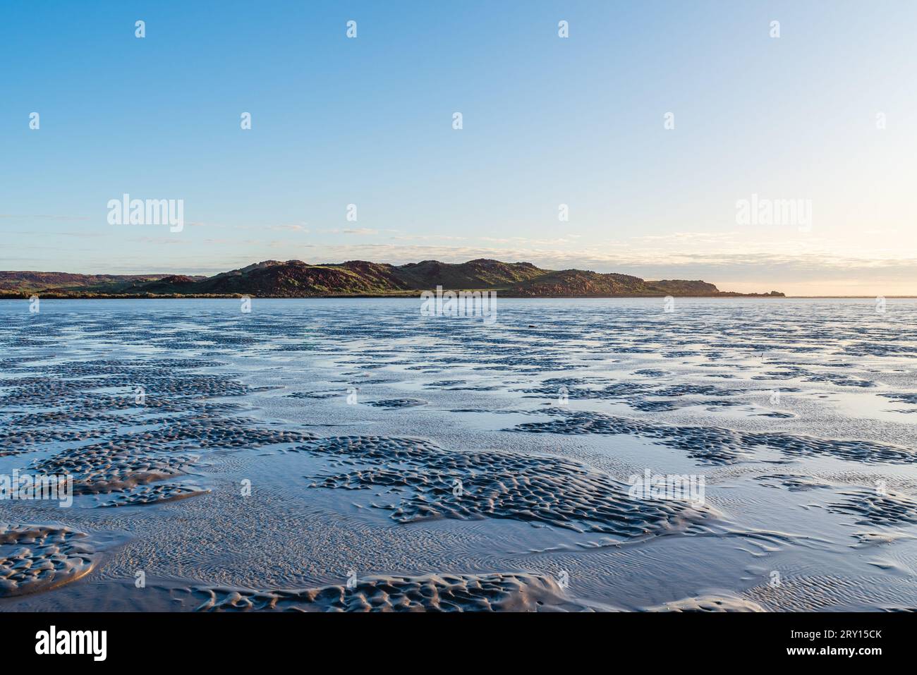 Looking out and accrose the exposed beach during sunrise and a low tide ...