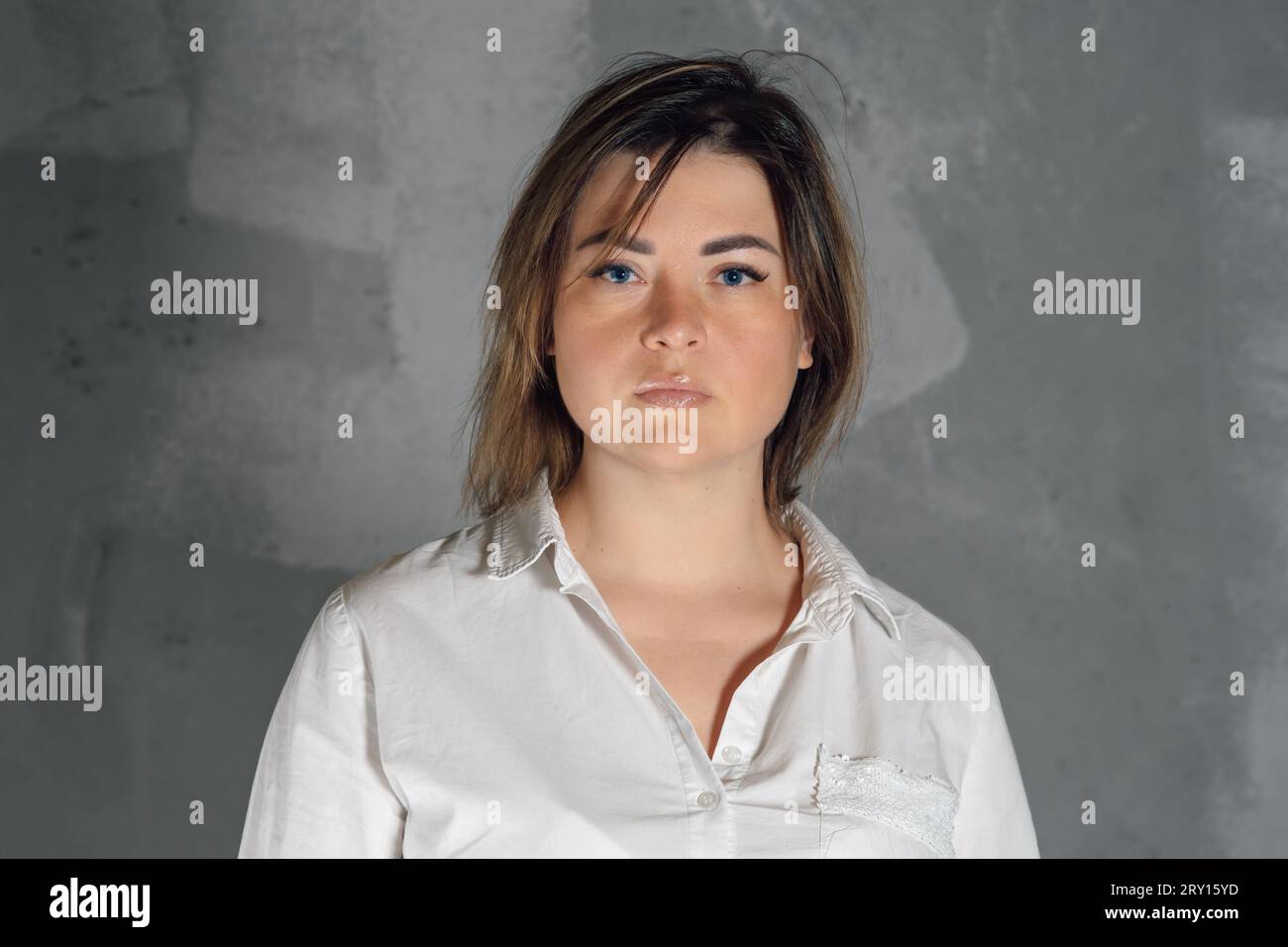 Portrait of gorgeous young woman with brown short hair standing against ...