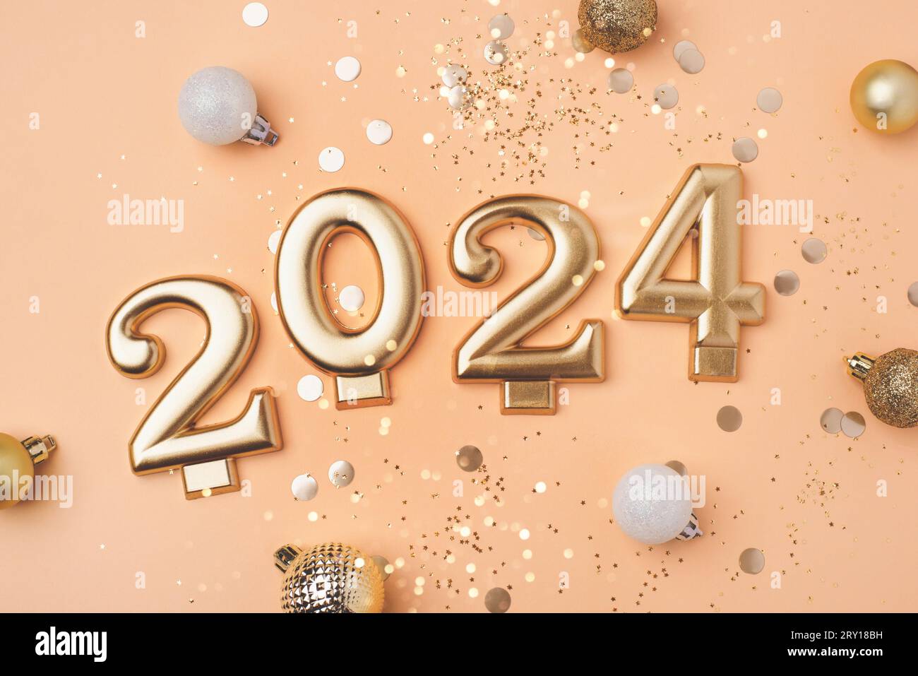 Golden 2024 on a peach color background with confetti and bokeh lights. Happy New Year 2024 is ...